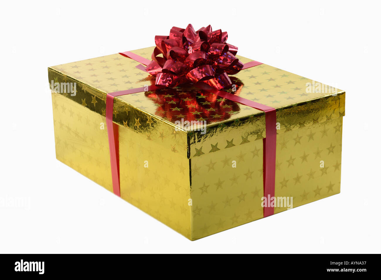 Still life of a shiny gold gift wrapped present with an ornate red bow ...