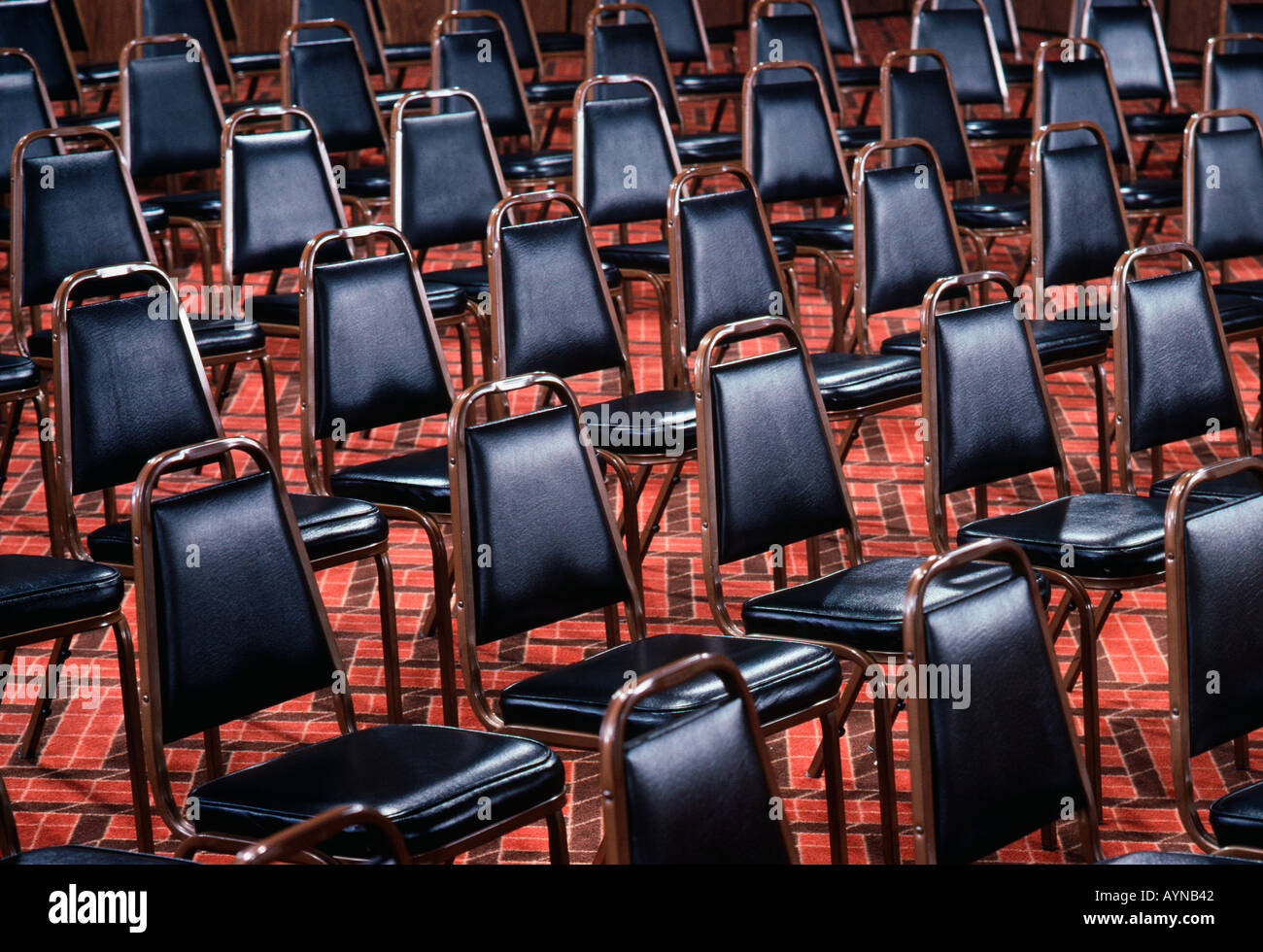Lineup of empty vinyl covered steel chairs awaiting a meeting in a ...