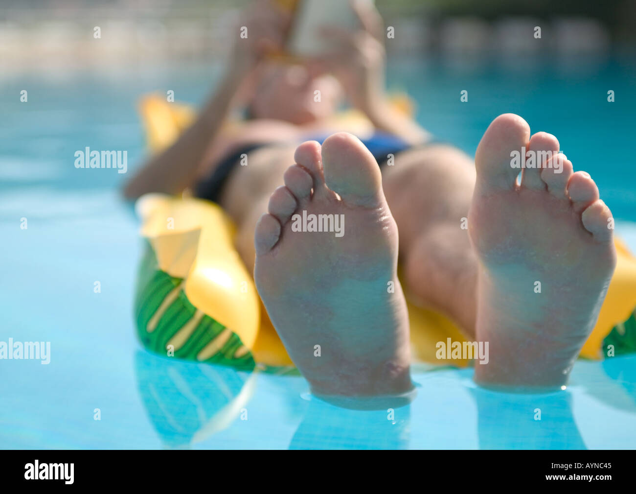 man feet first reading book while floating on swimming pool Stock Photo ...