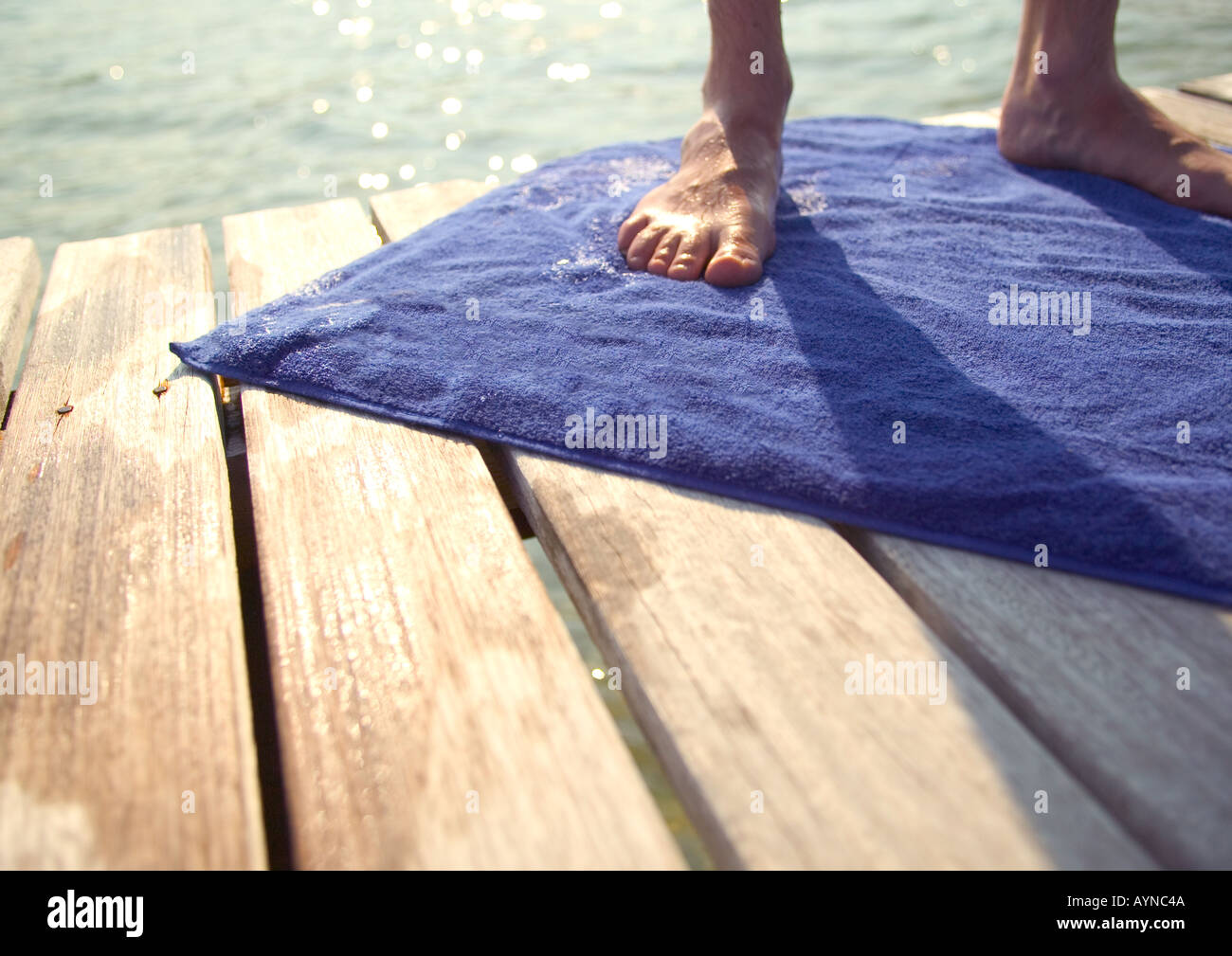 feet of man on towel standing jetty at sea Stock Photo - Alamy