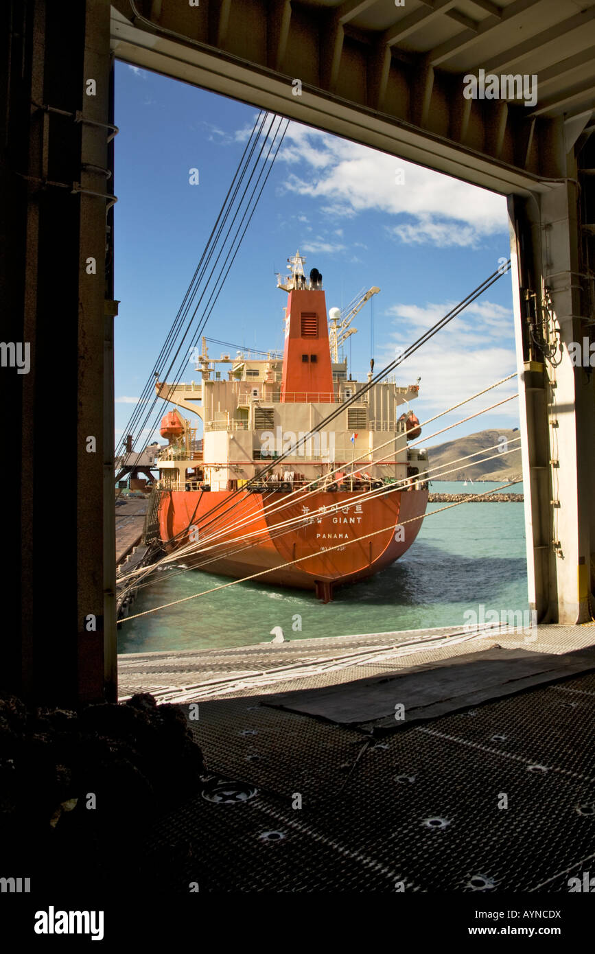 A cargo ship moored alongside the quayside as seen through the stern ...
