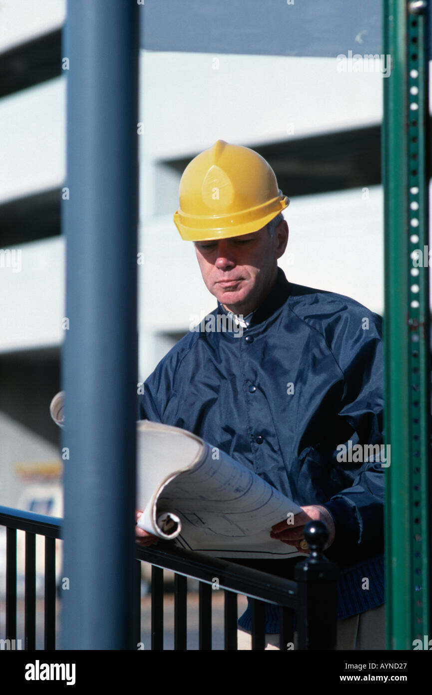 Caucasian construction foreman looking at blueprints on a construction ...