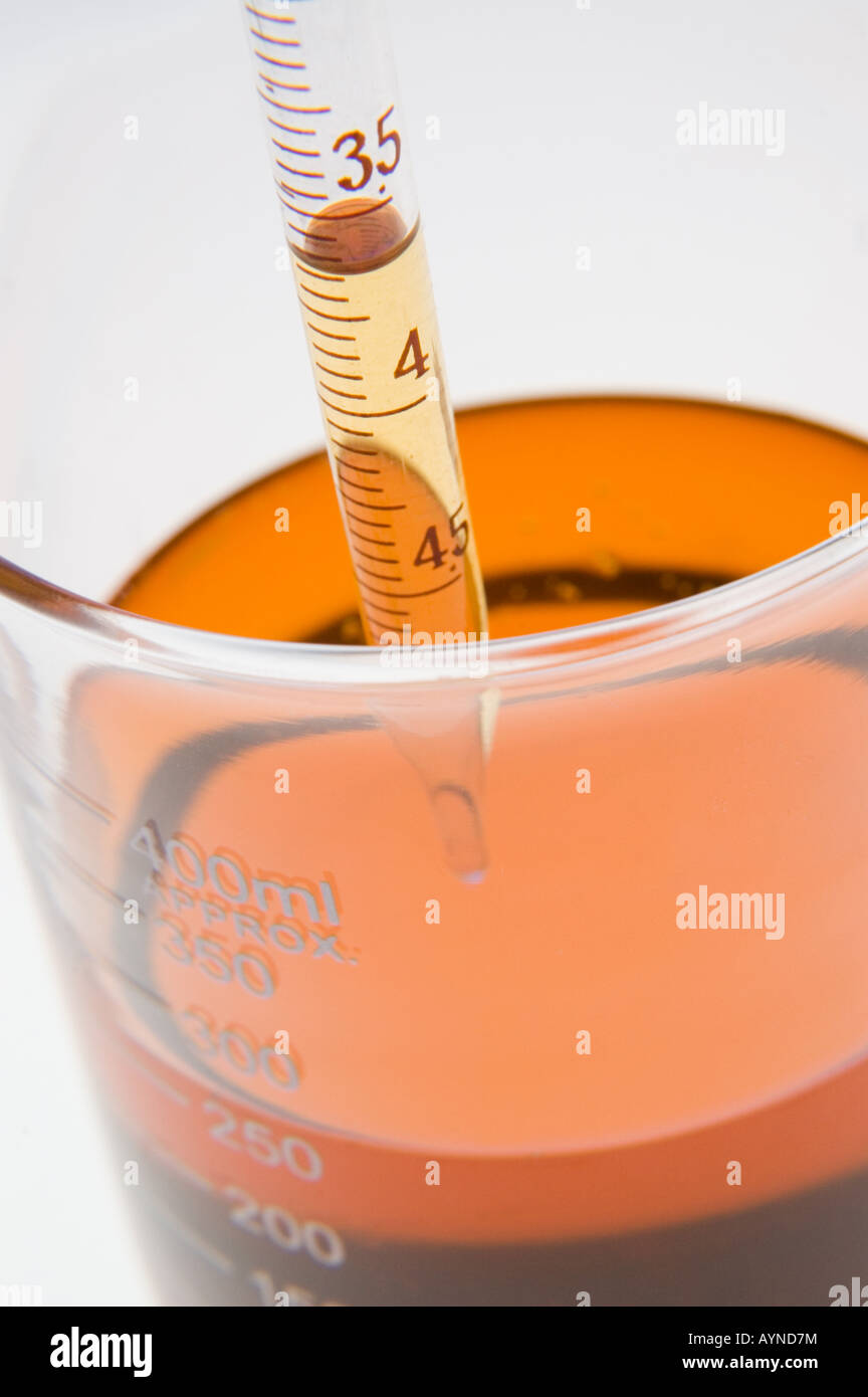 Pipette measuring a quantity of oil from a beaker Stock Photo - Alamy
