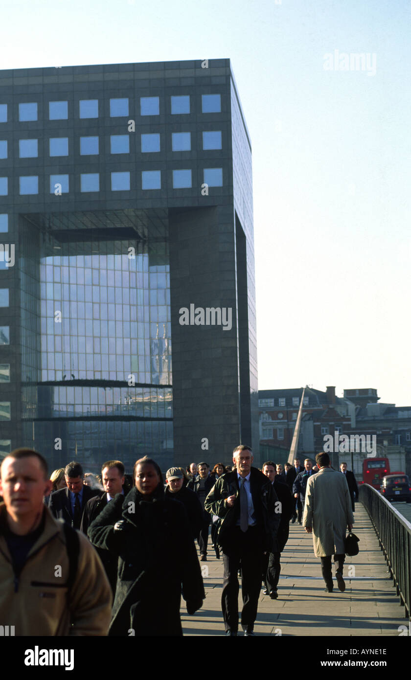 Commuters walking over London Bridge in the early morning rush hour ...
