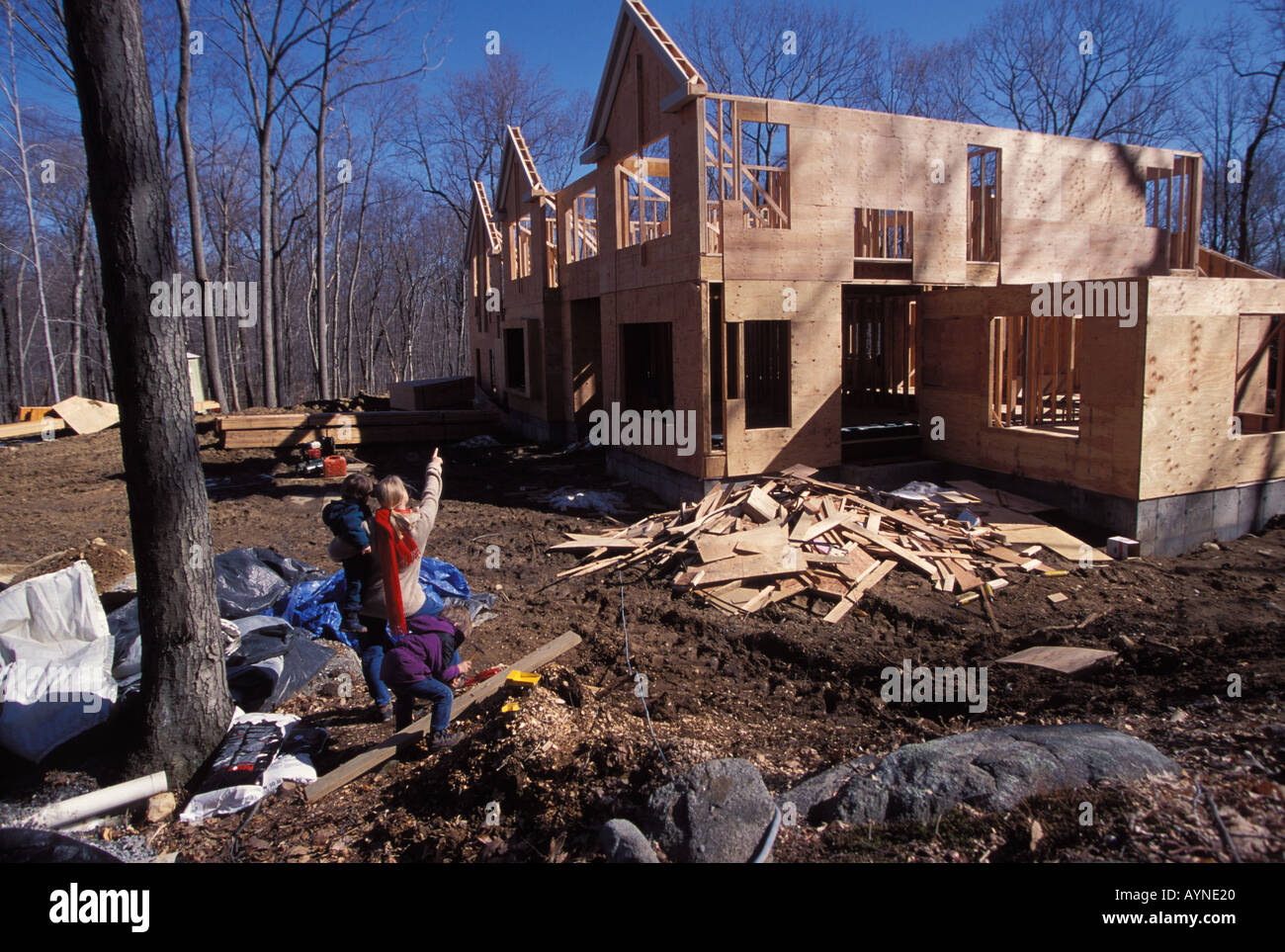 Mother and her two young boys on a construction site looking at their ...