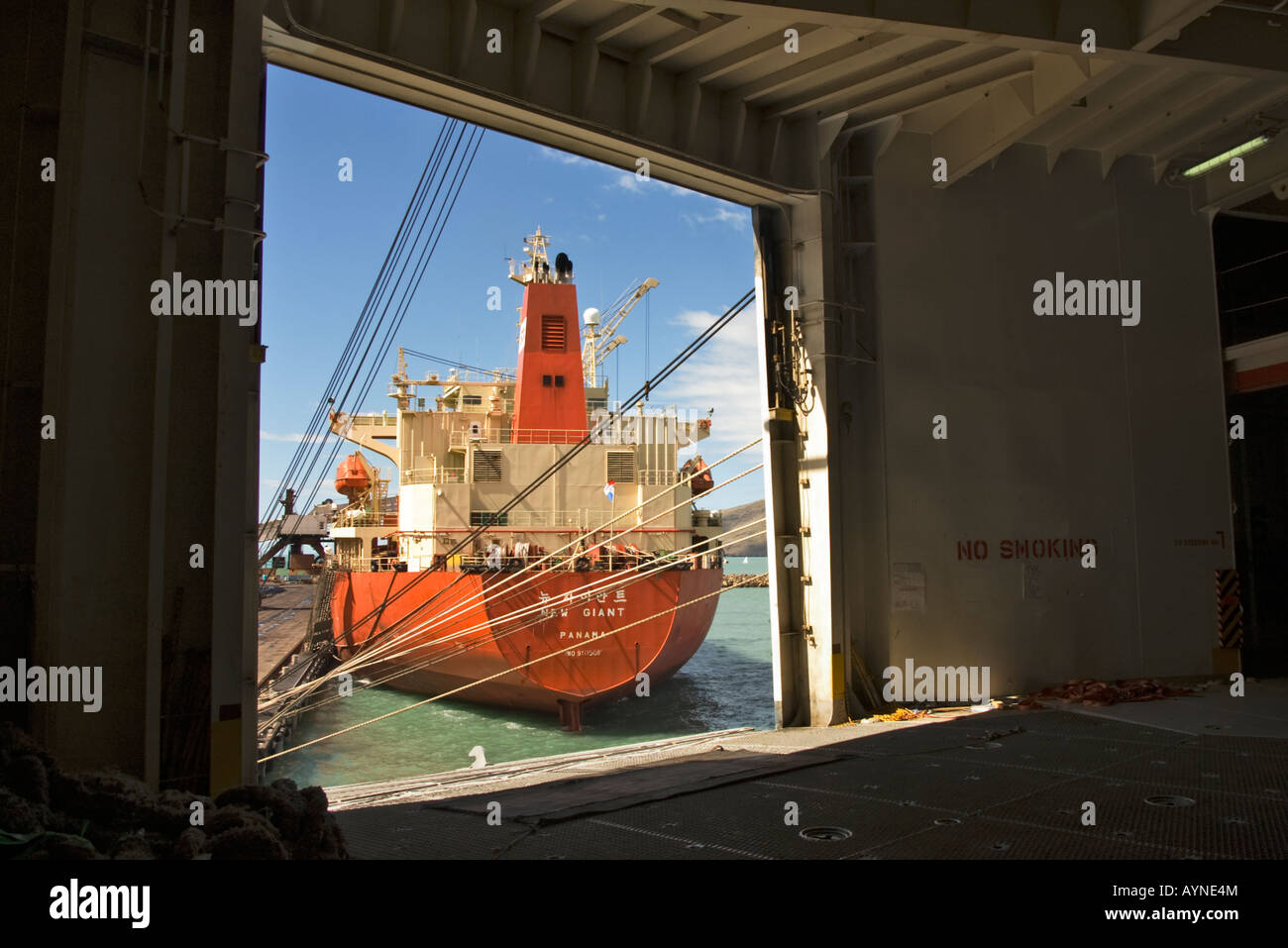 A cargo ship moored alongside the quayside as seen through the stern ...