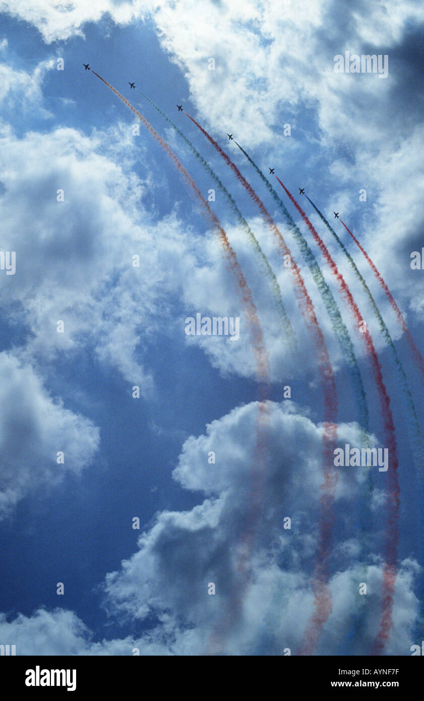 Red arrow jet trainers flying in formation with multi coloured smoke ...