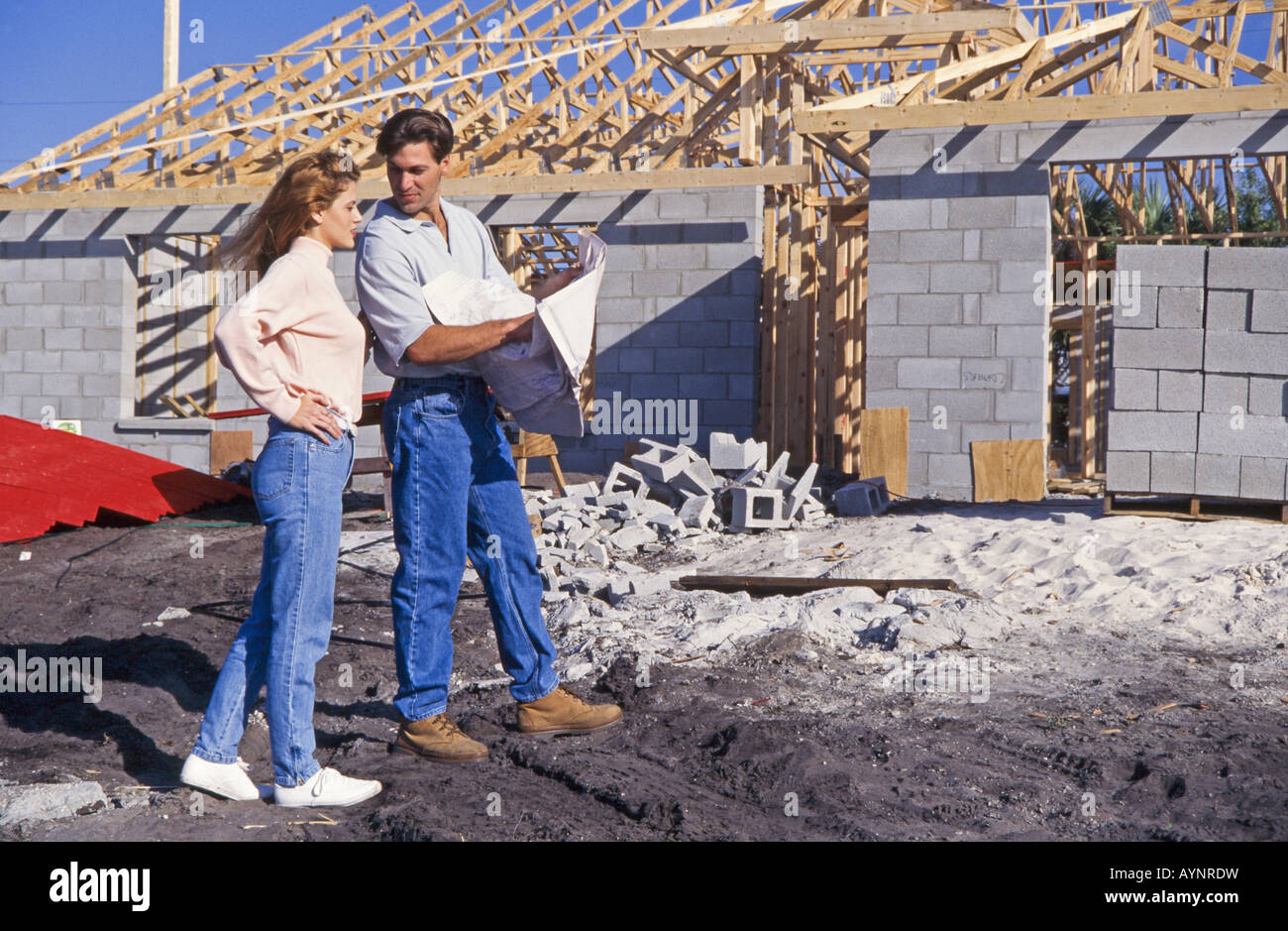 Young Couple at home building site, with building plans, Miami Stock ...