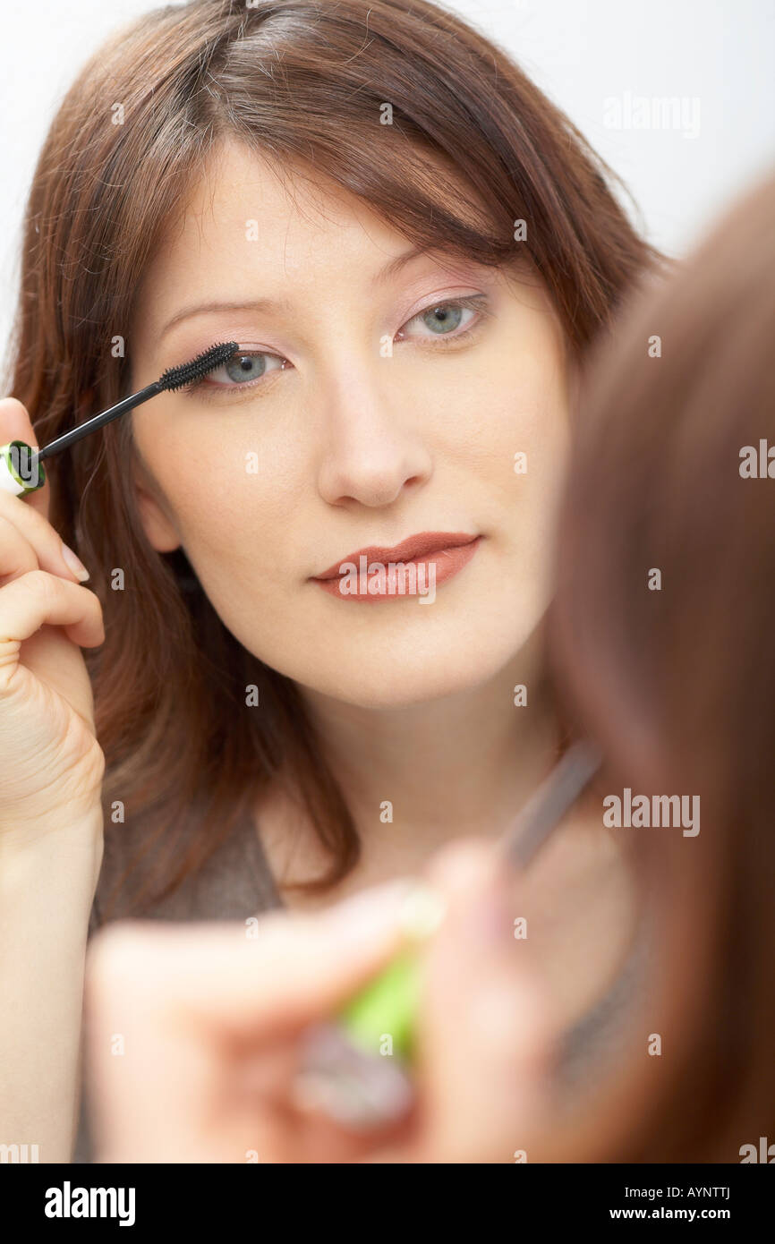 Portrait of a woman applying mascara Stock Photo - Alamy