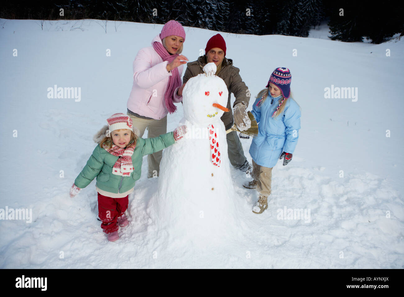 Family making a snowman Stock Photo - Alamy