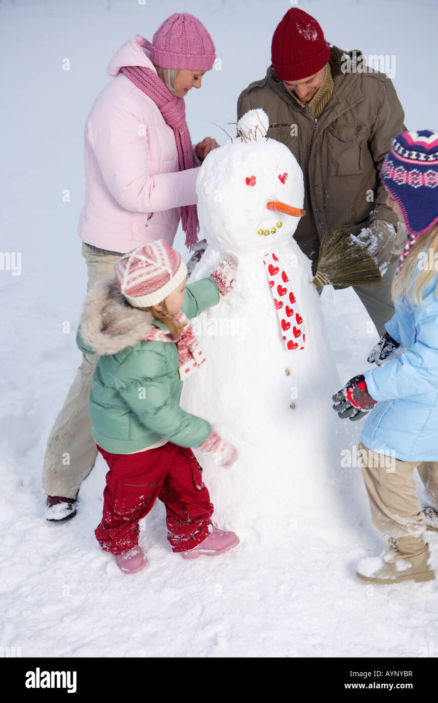 Family making a snowman Stock Photo - Alamy