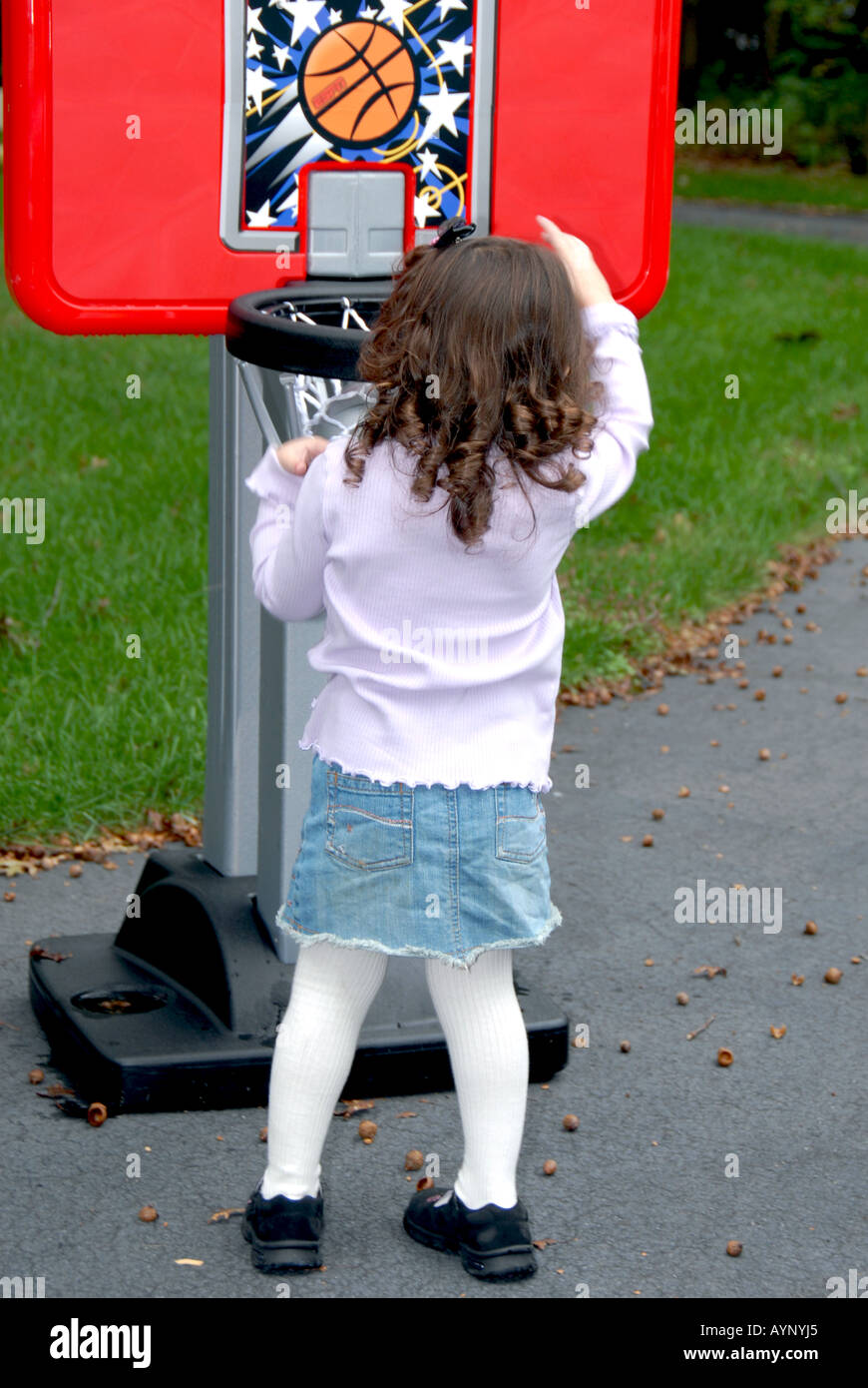Three year old girl tossing a basketball into a net Stock Photo - Alamy