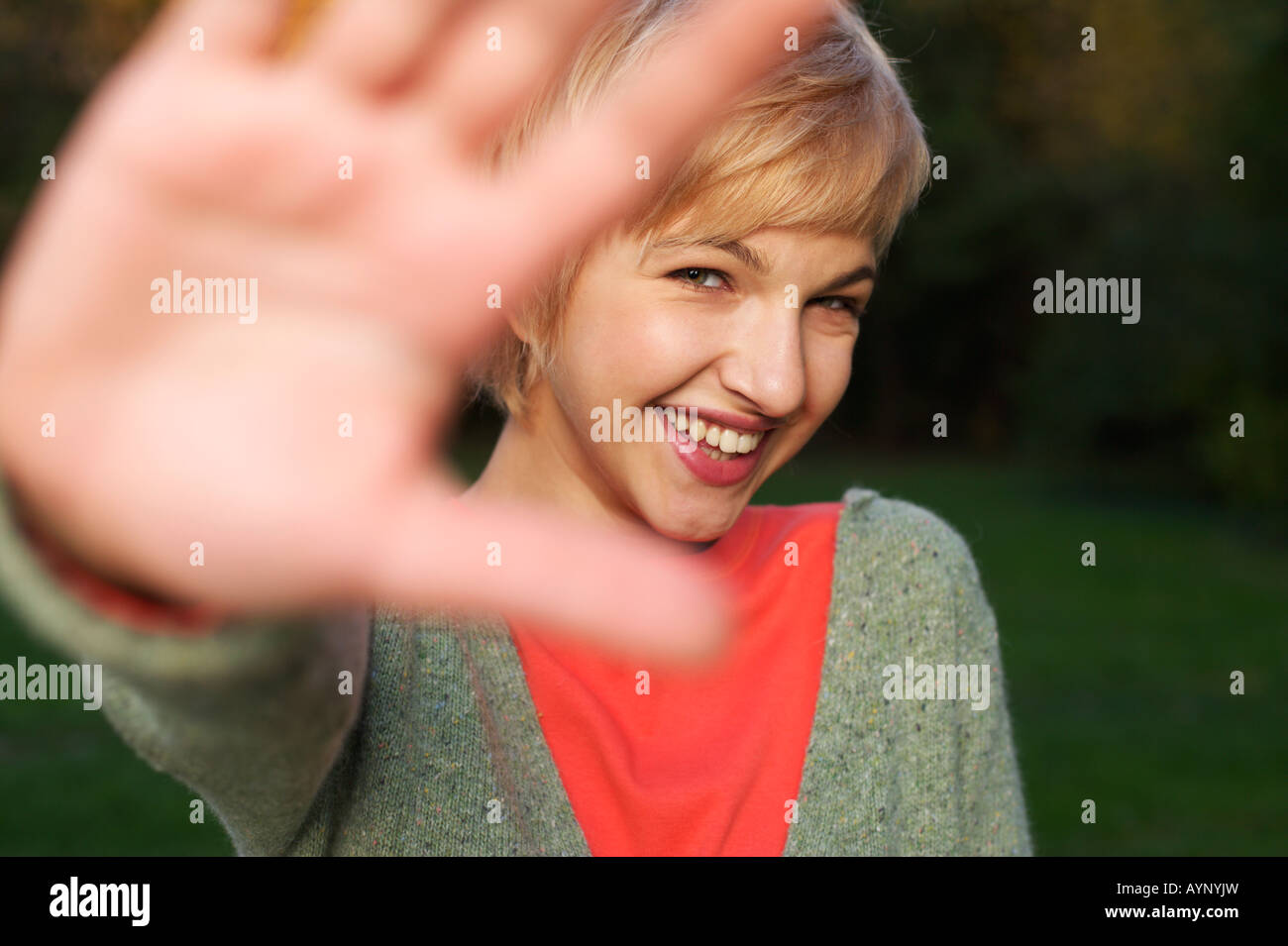 Blonde girl holding her hand in front of her face, close-up, selective ...