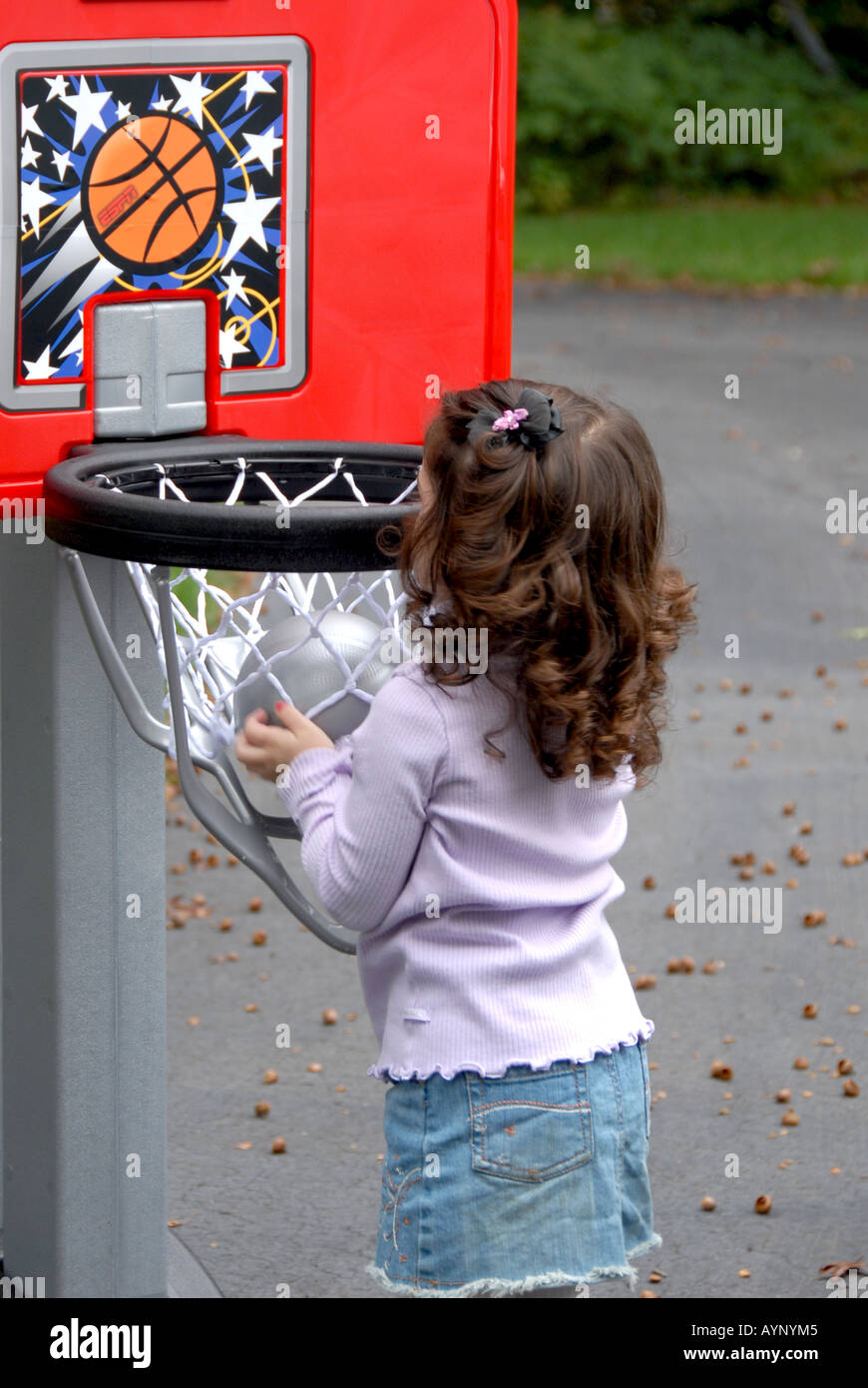 Three year old girl watching a basketball fall through a hoop Stock ...