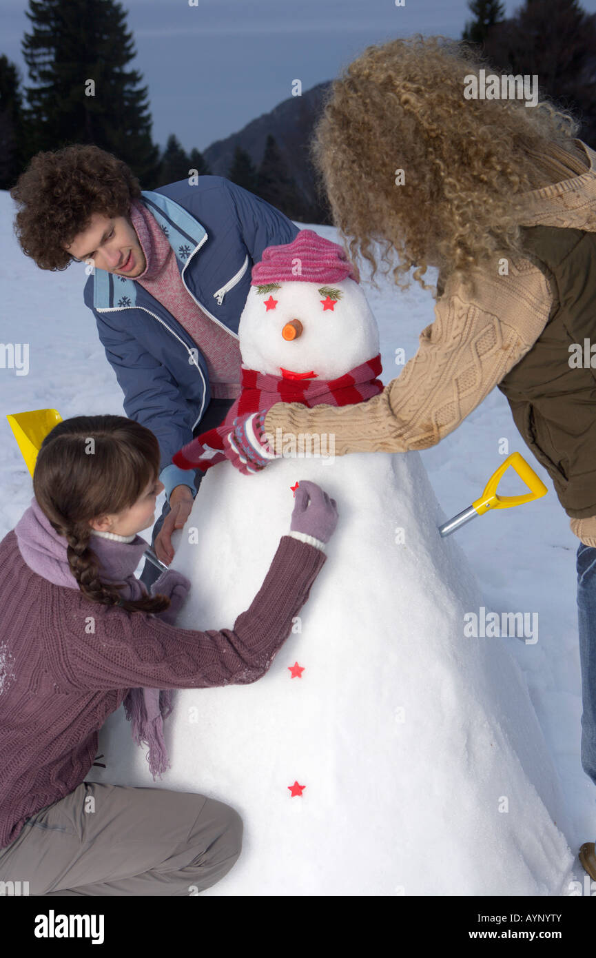 Group young people building snowman hi-res stock photography and images ...
