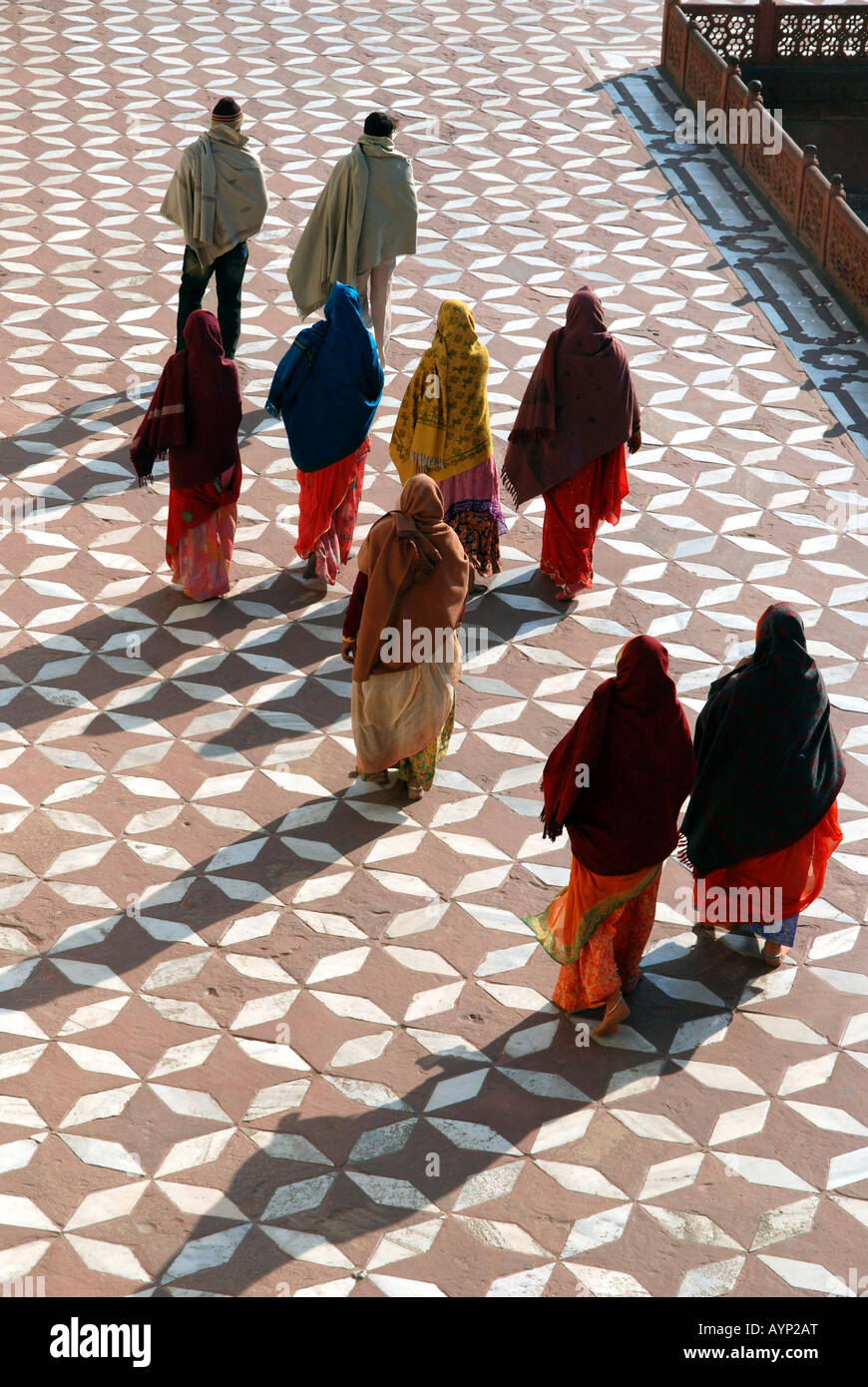 People in traditional Indian dress walking on the patterned paving ...
