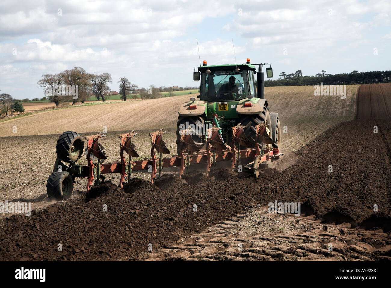Tractor ploughing soil in preparation for potato crop, Butley, Suffolk ...