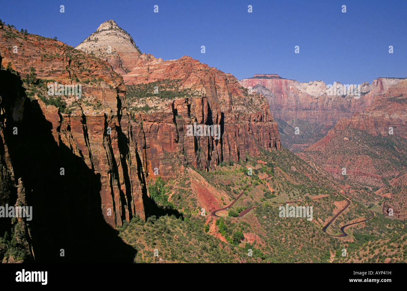 A road zig zags up Zion Canyon and the red sandstone monuments and ...