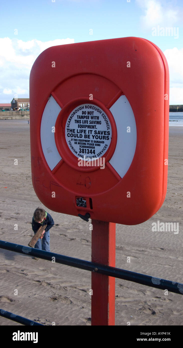 Life saving equipment on beach, boy playing in background Stock Photo ...
