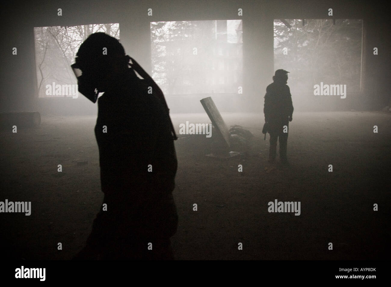 Shadows of two soldiers covered with dense smoke form a smoke grenade ...
