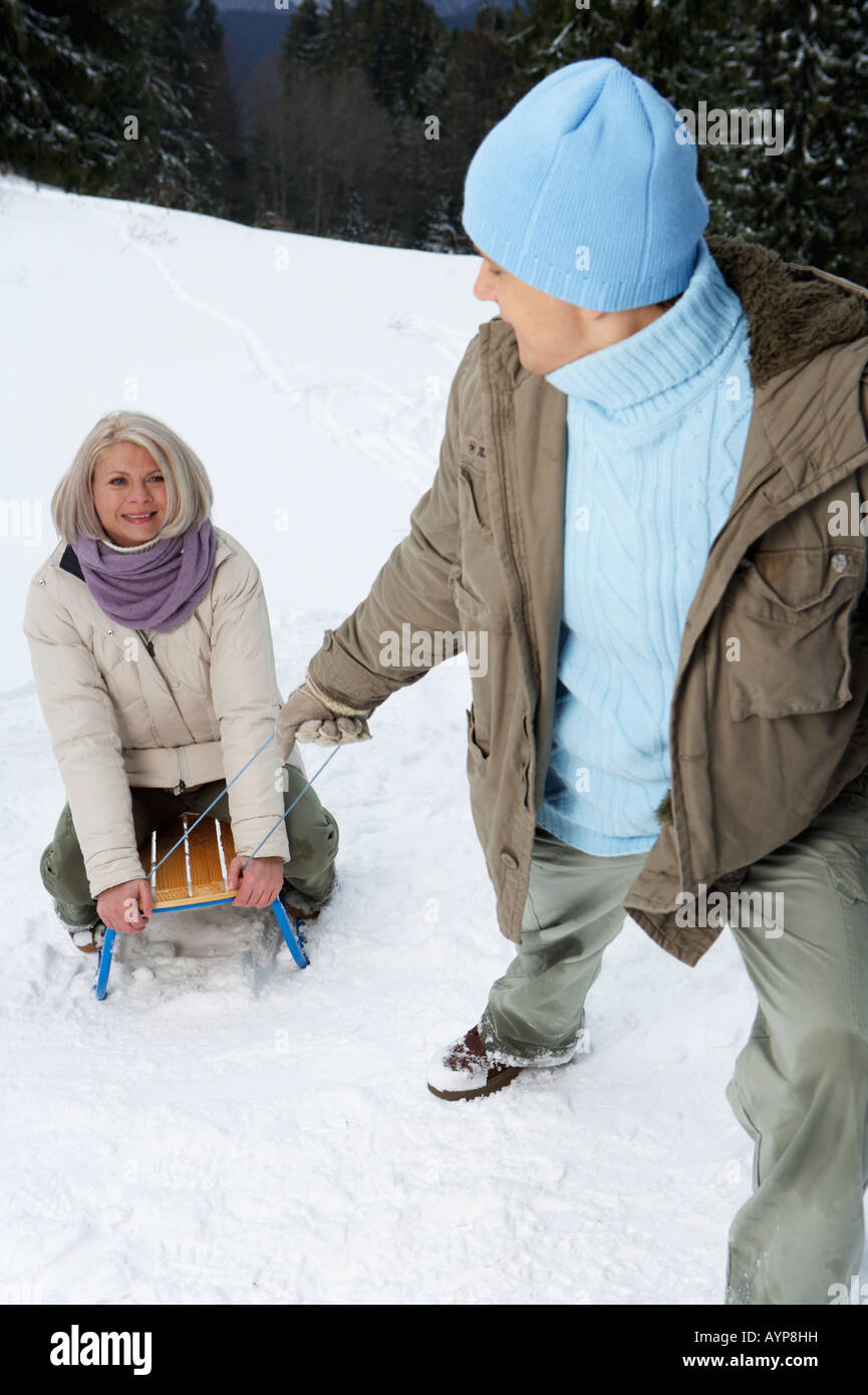 Mann pulling woman on sled Stock Photo - Alamy