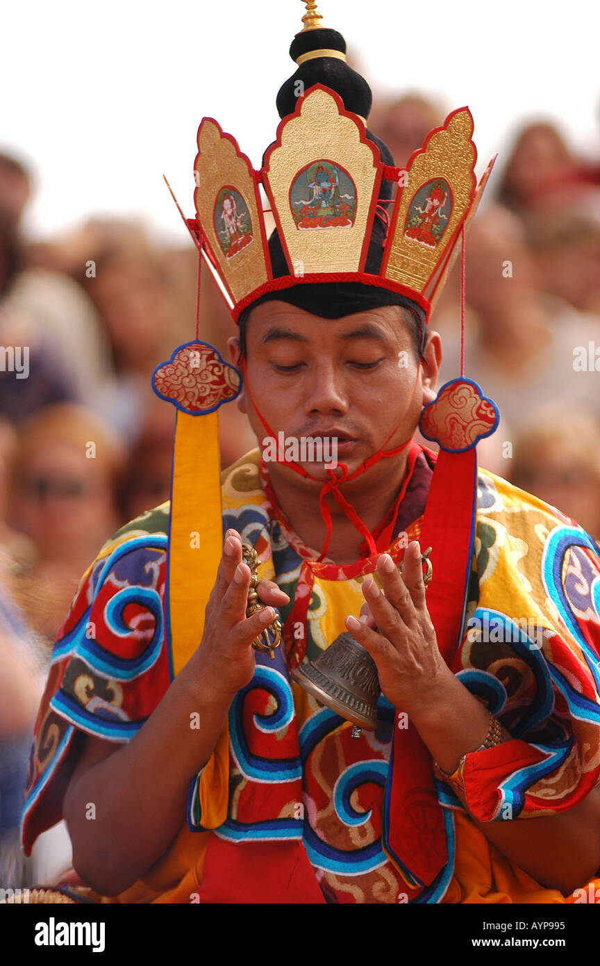 Buddhist monk performing a traditional Fire Puja ritual, wearing a ...