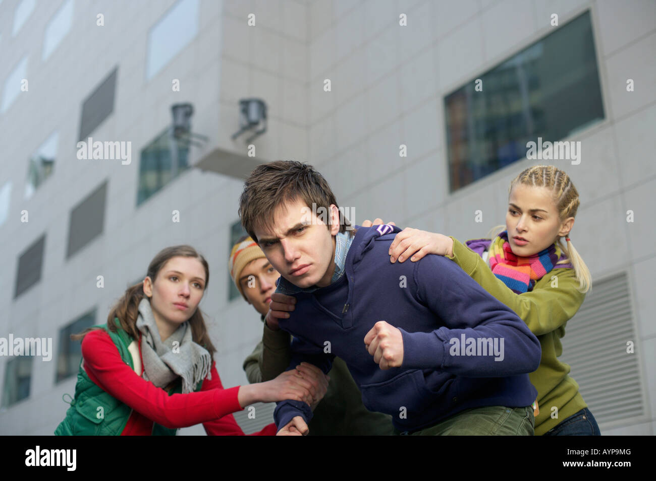 Group keeping back young aggressive man Stock Photo - Alamy