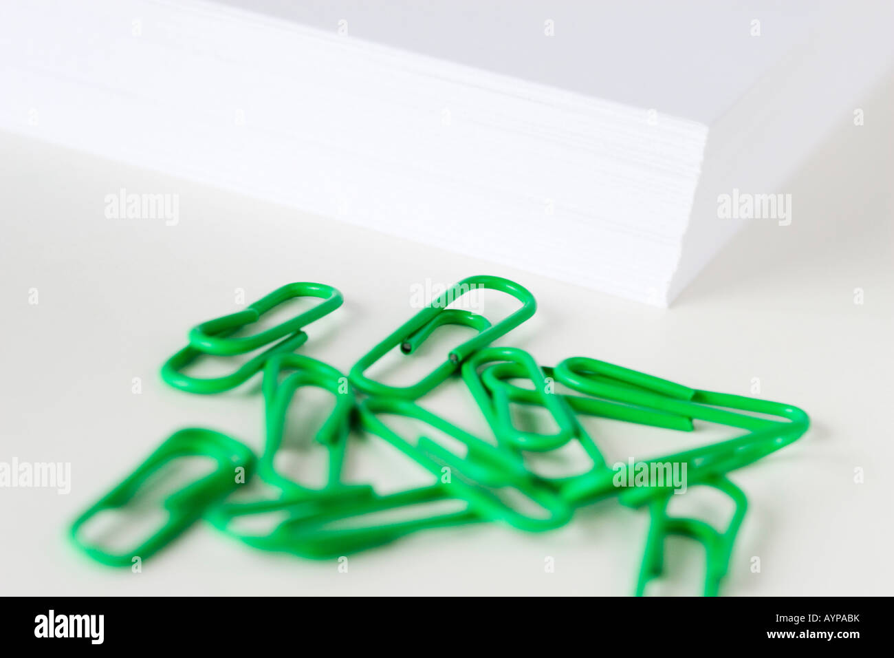 Green Paper clips and a stack of papers Stock Photo - Alamy