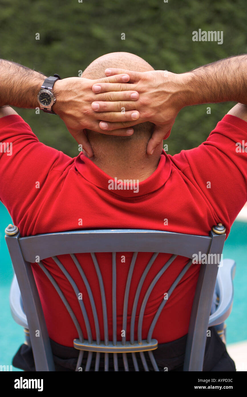 Bald man with hands locked behind his head Stock Photo - Alamy
