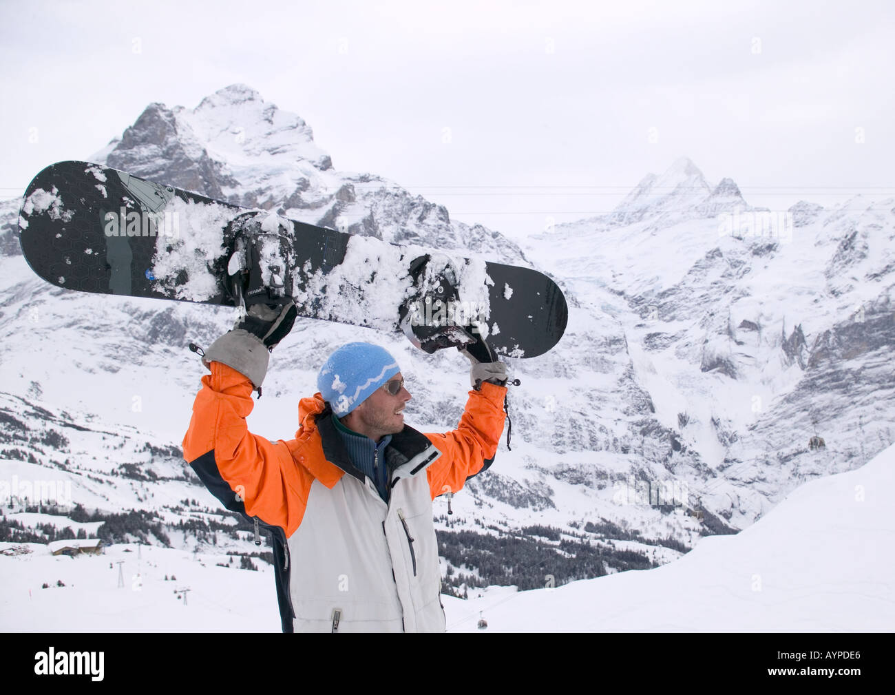 snowboarder holding snowboard above head on slope Stock Photo - Alamy