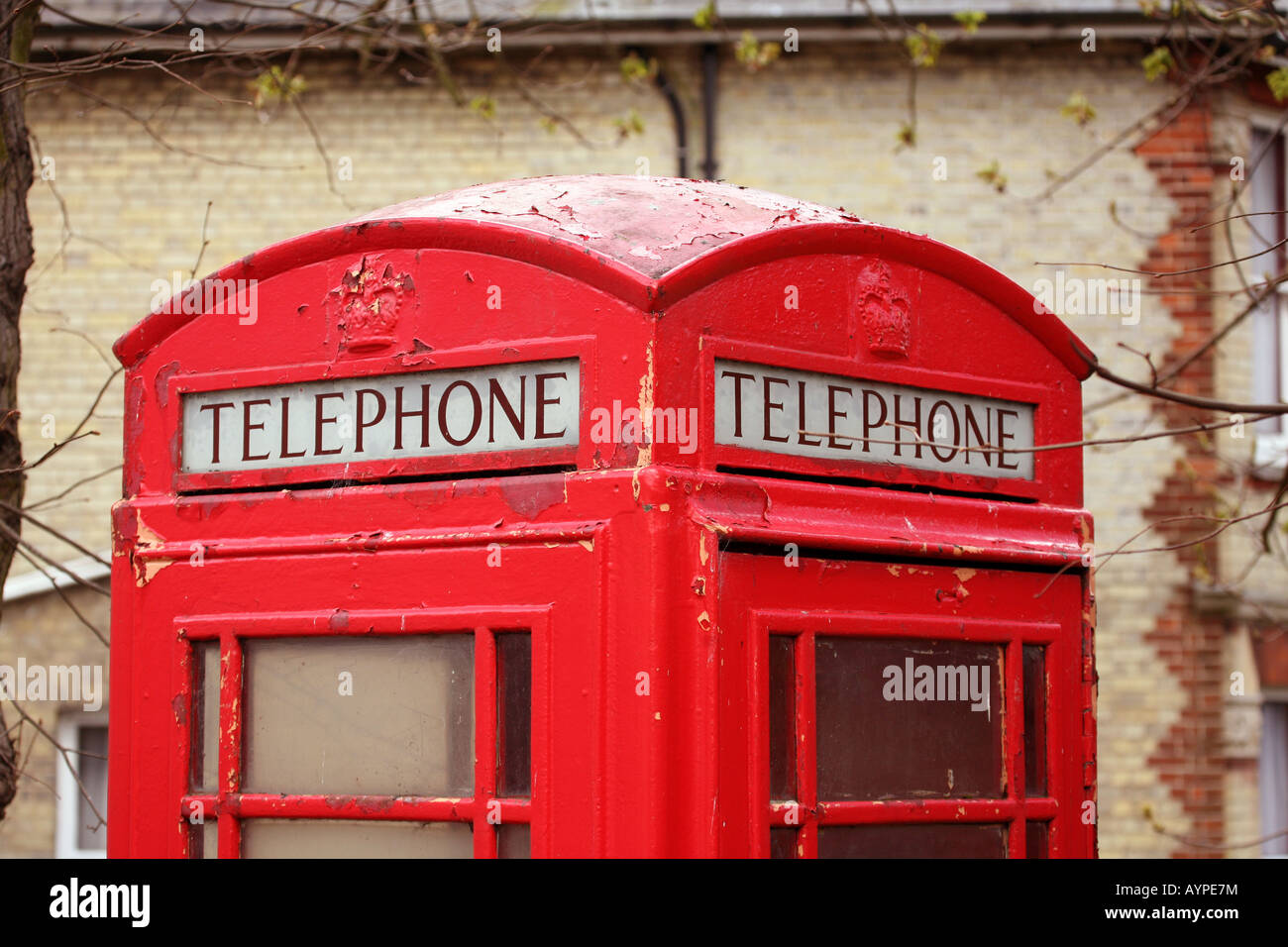 The top of an old-fashioned red telephone box with peeling paint ...