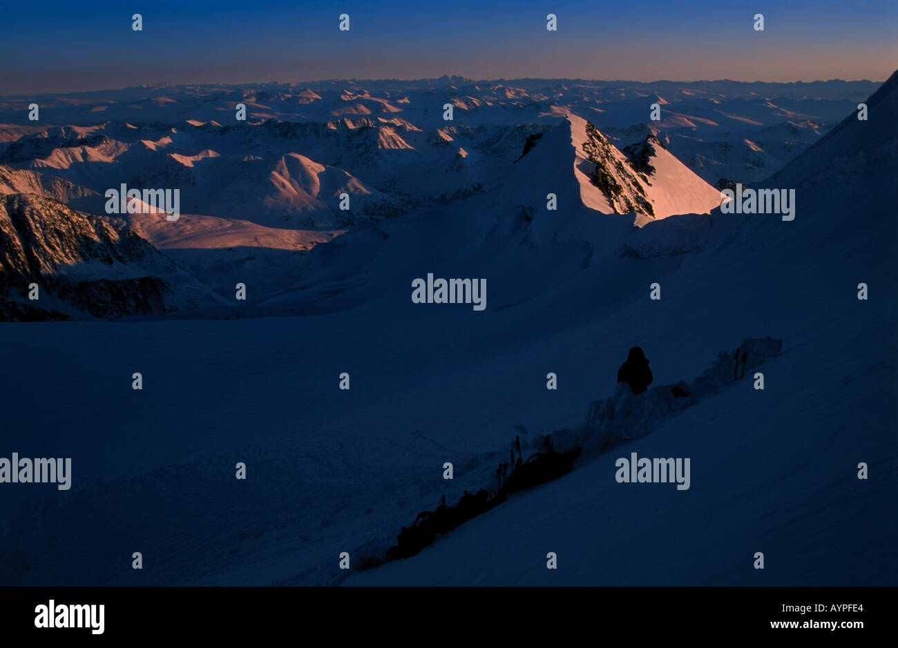 Mountain climber is digging a snow cave for spending the night Altai ...
