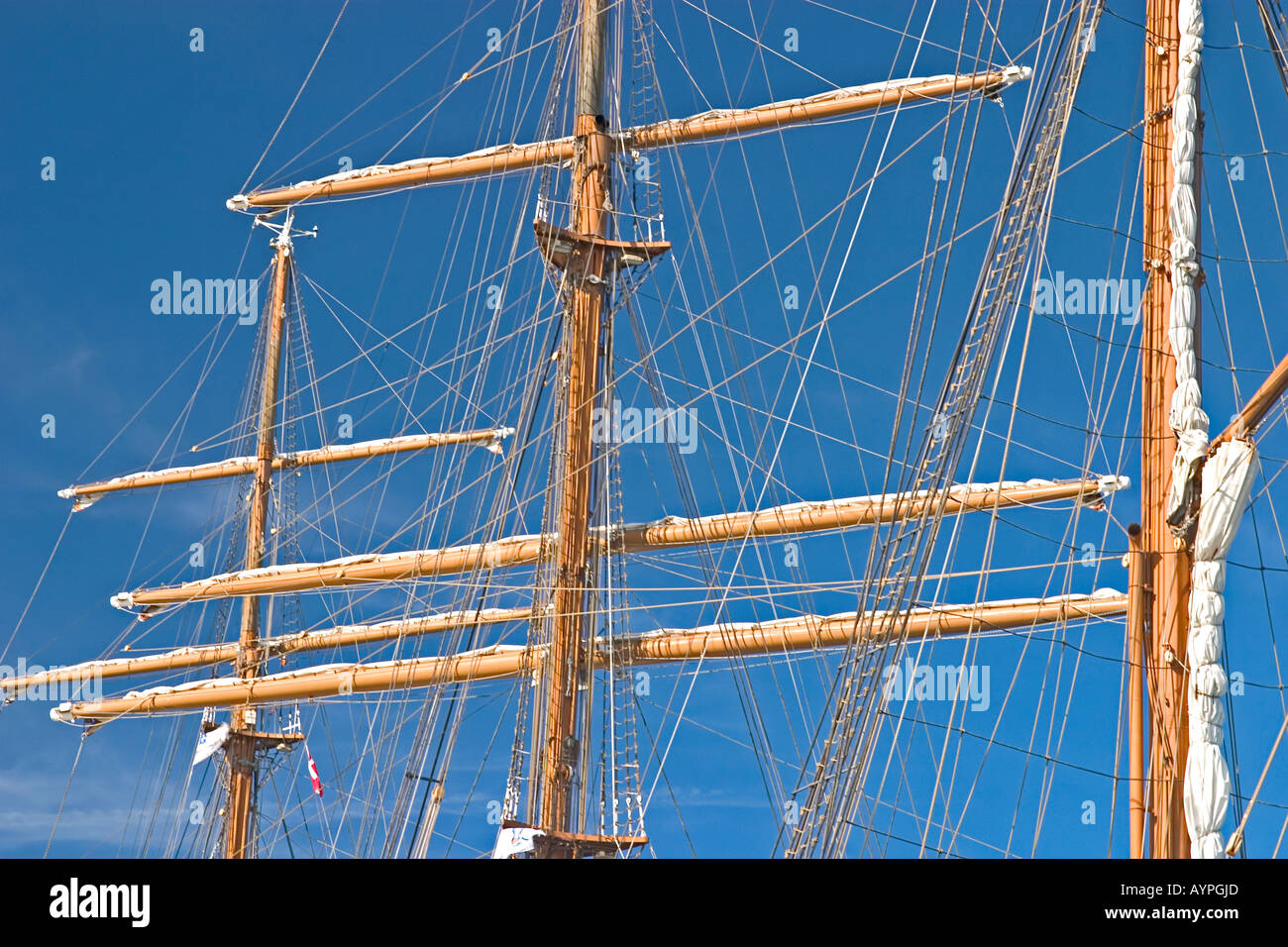 Tall ship sail masts against a blue sky Three masted large schooner ...