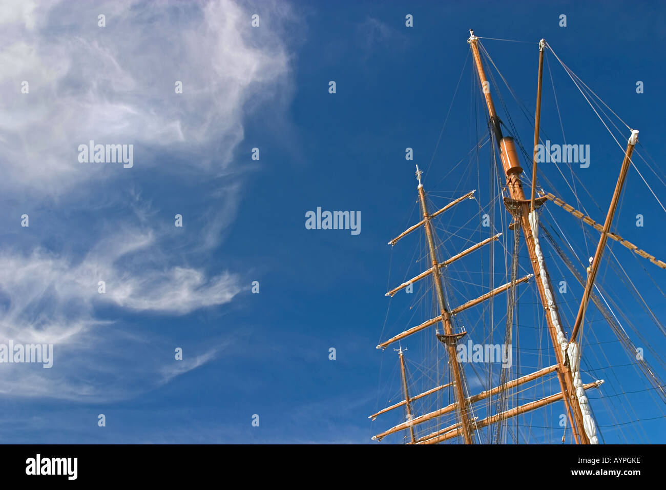 Tall ship sail masts against a blue sky Three masted large schooner ...