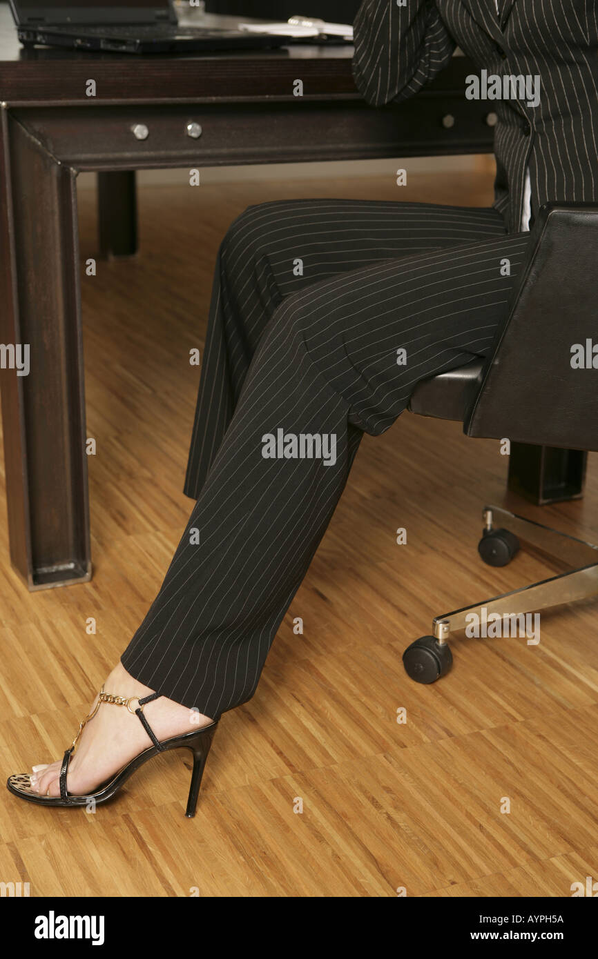 A businesswoman sitting in her office wearing high heels Stock Photo ...