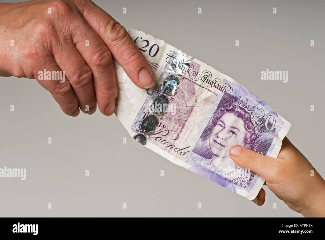 Stock photo of a parents hand handing over a twenty pound note to a ...