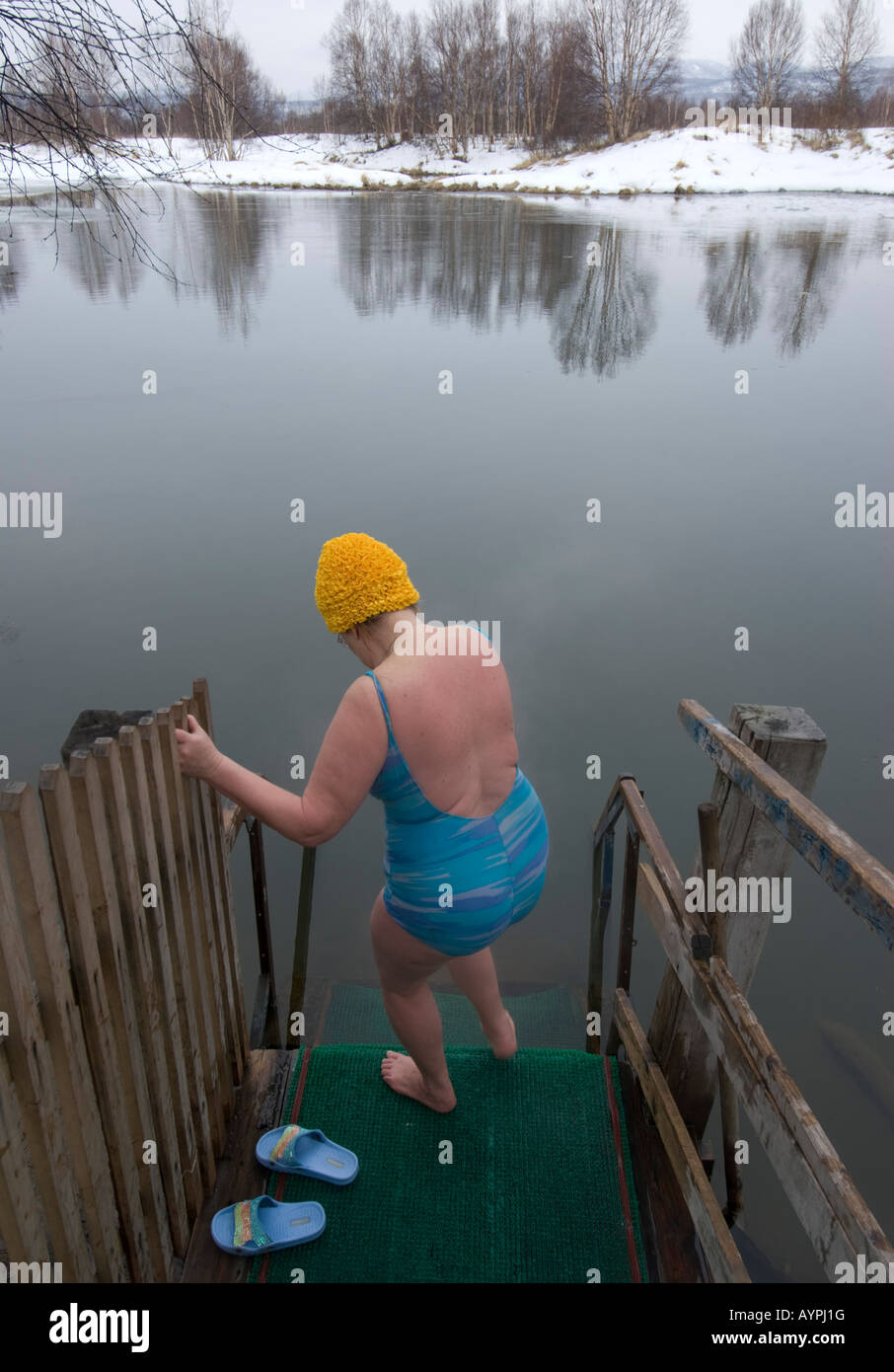 Woman about to swim in lake during winter at Ozerki hot springs near ...