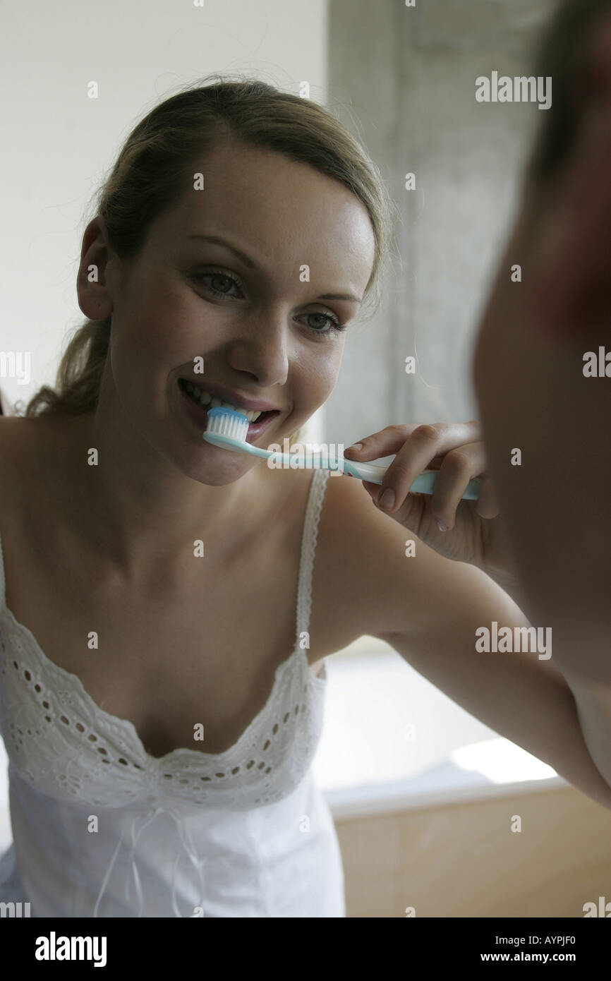 A blonde woman brushing her teeth Stock Photo - Alamy