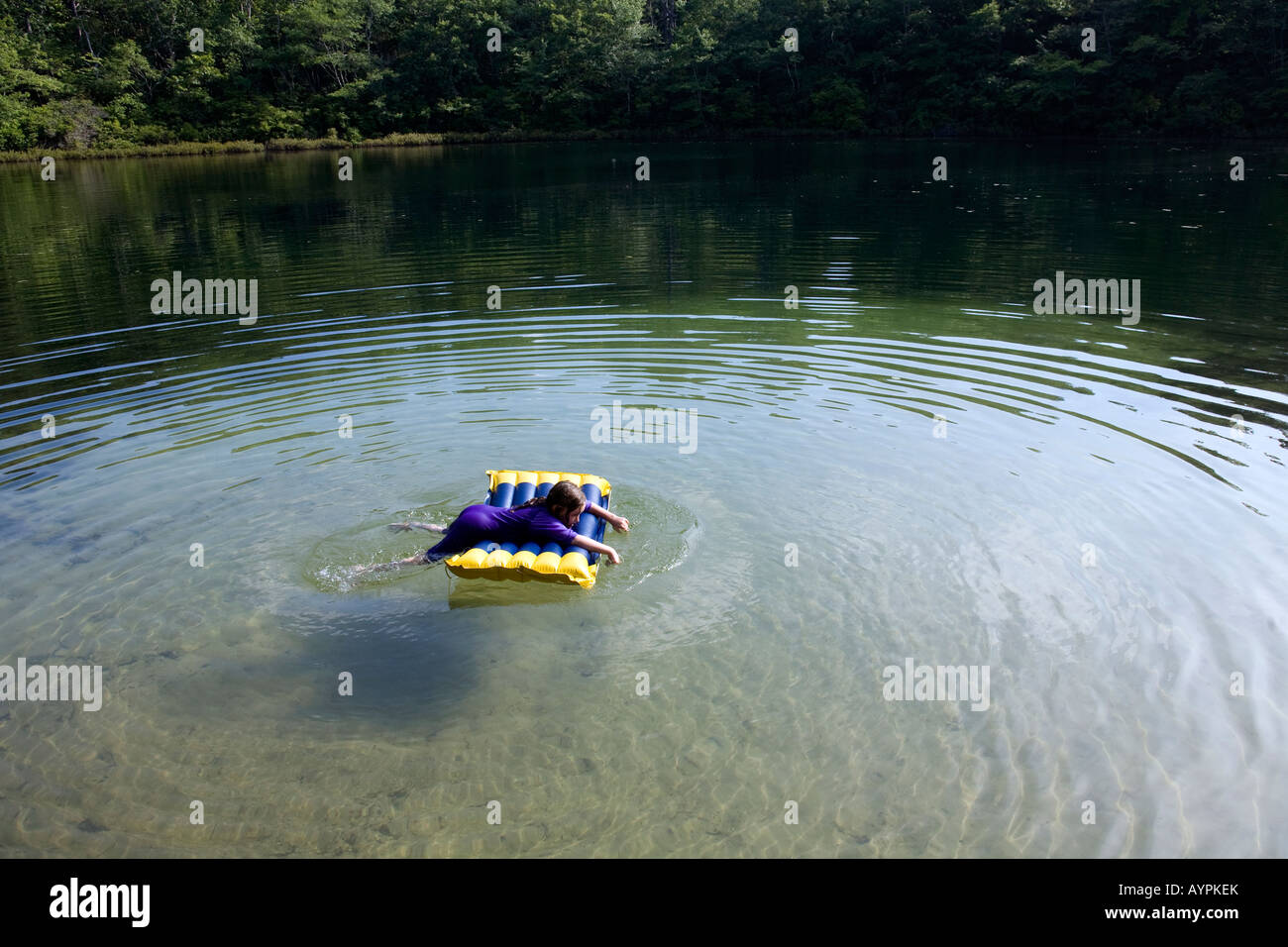 a young girl alone floating on a raft on a pond on Cape Cod Stock Photo ...