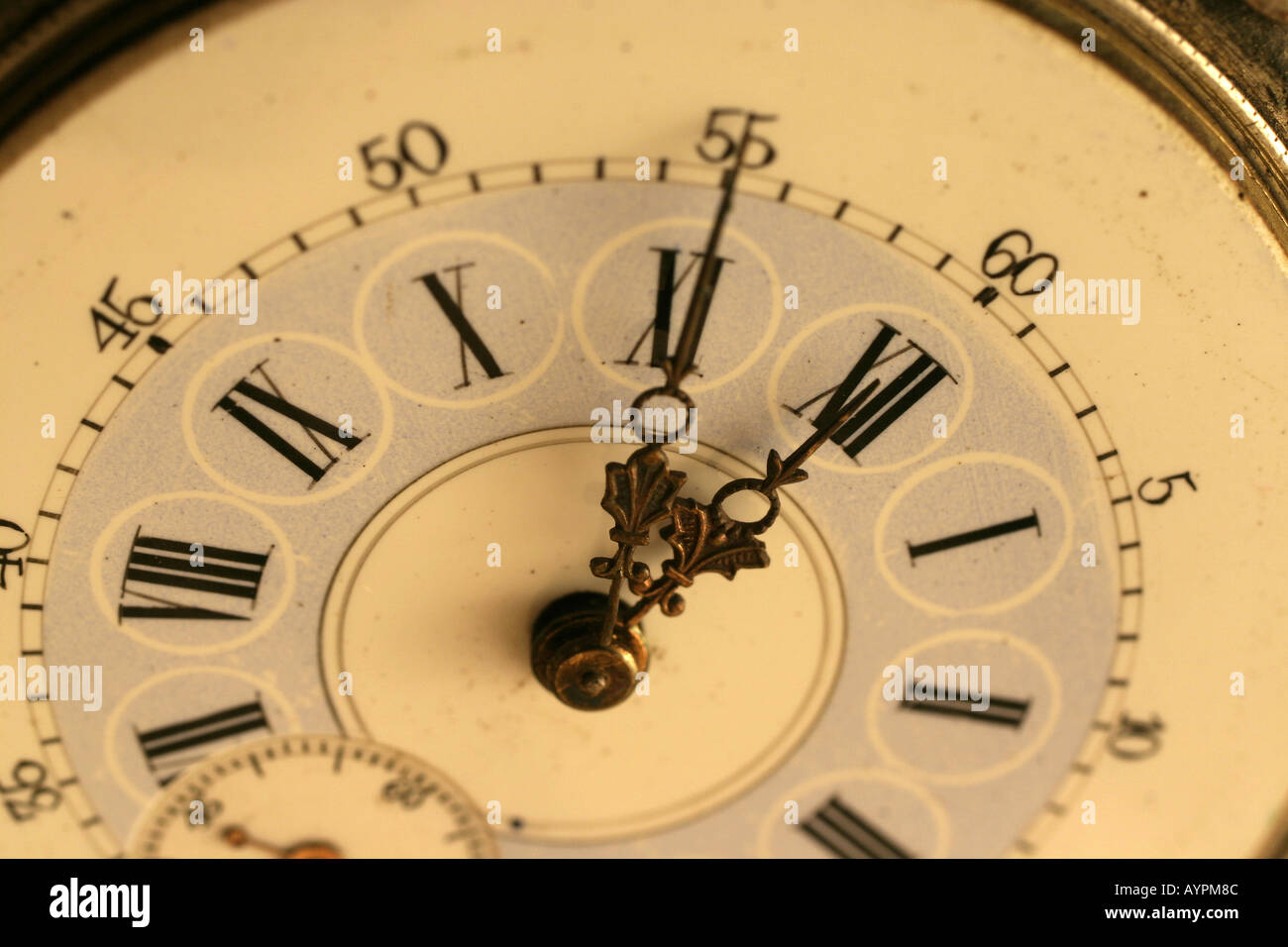 A close up of an antique pocket watch with Roman numbers on the dial ...