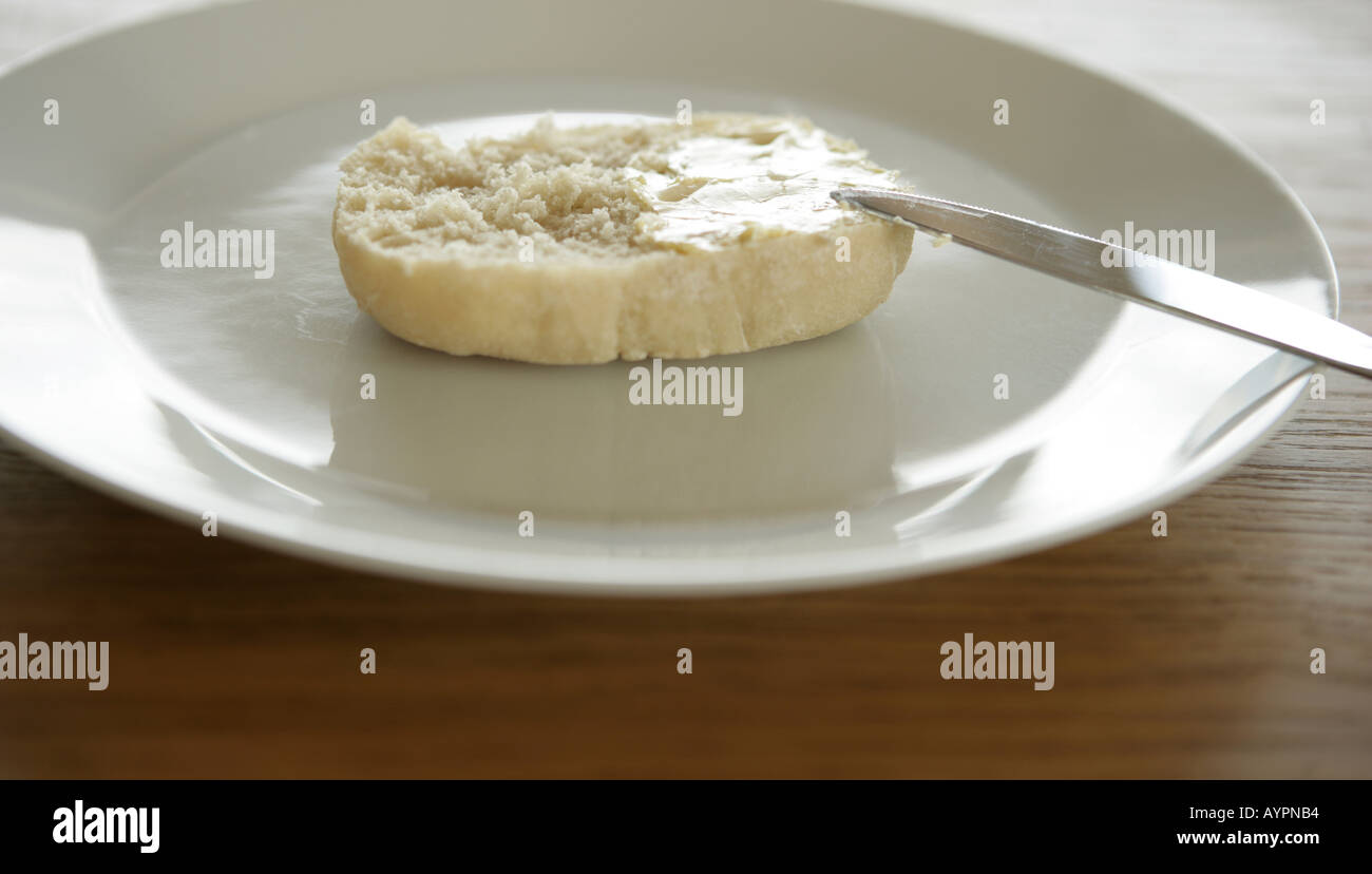A half roll with butter applied on it placed in the center of the dish ...