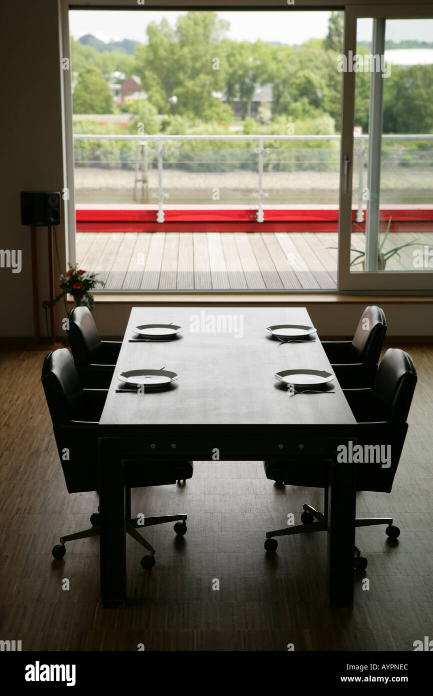 An organized dining table and chairs seen beside an adjoining patio ...