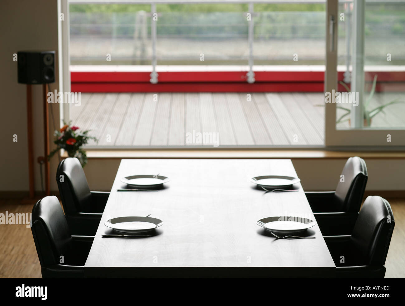 An organized dining table and chairs seen beside an adjoining patio ...