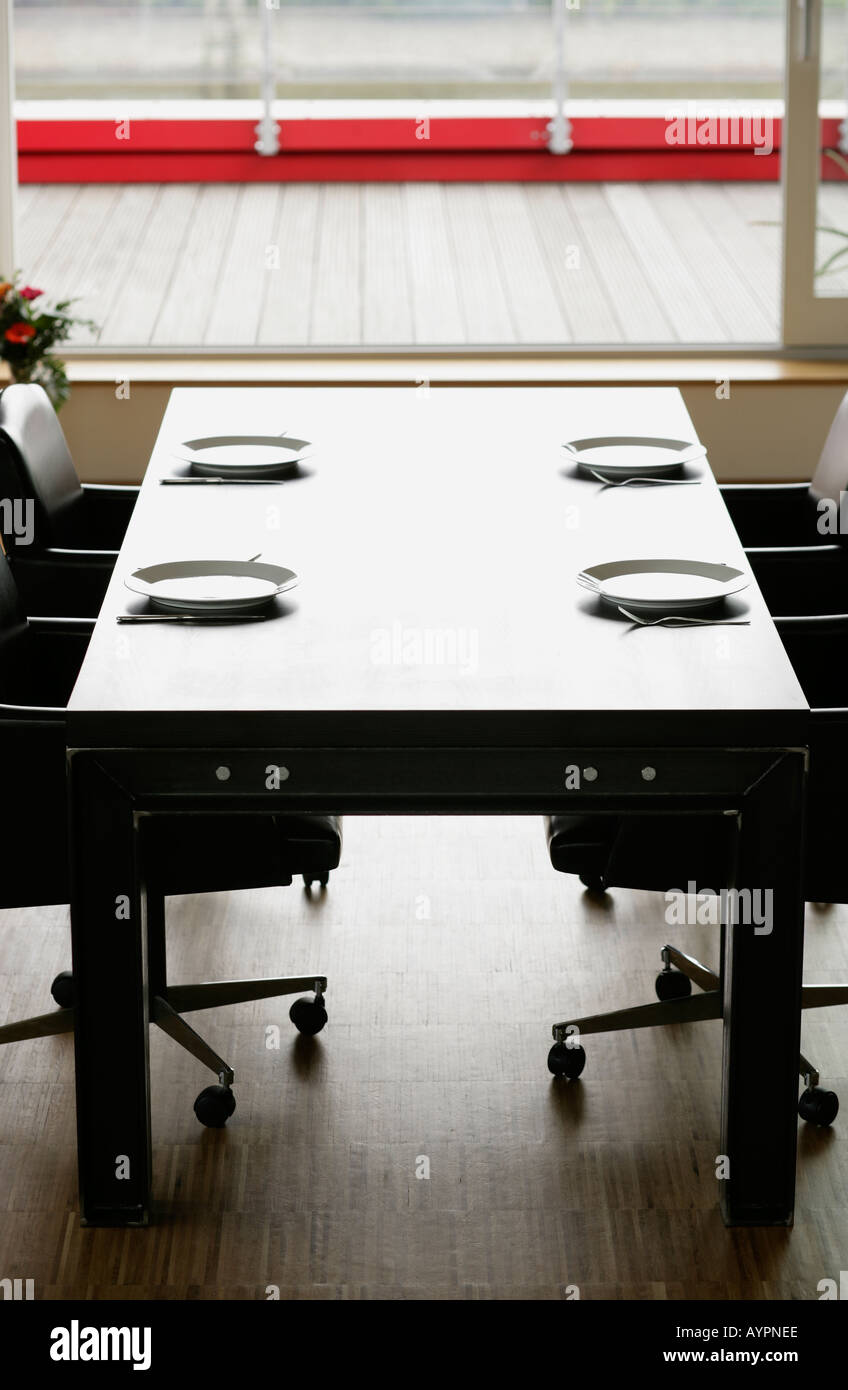 An organized dining table and chairs seen beside an adjoining patio ...