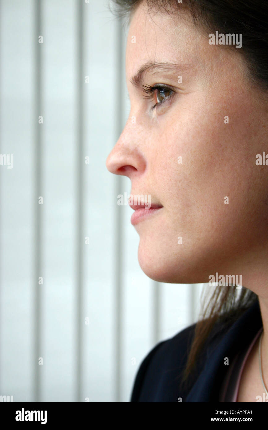 Side view of a woman seen as she is pleased by looking at something ...