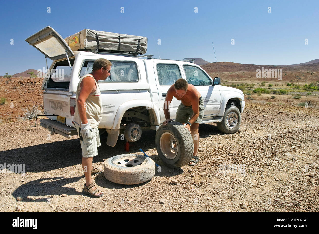 Changing a flat tire on an off-road vehicle (4X4) in northern Namibia ...