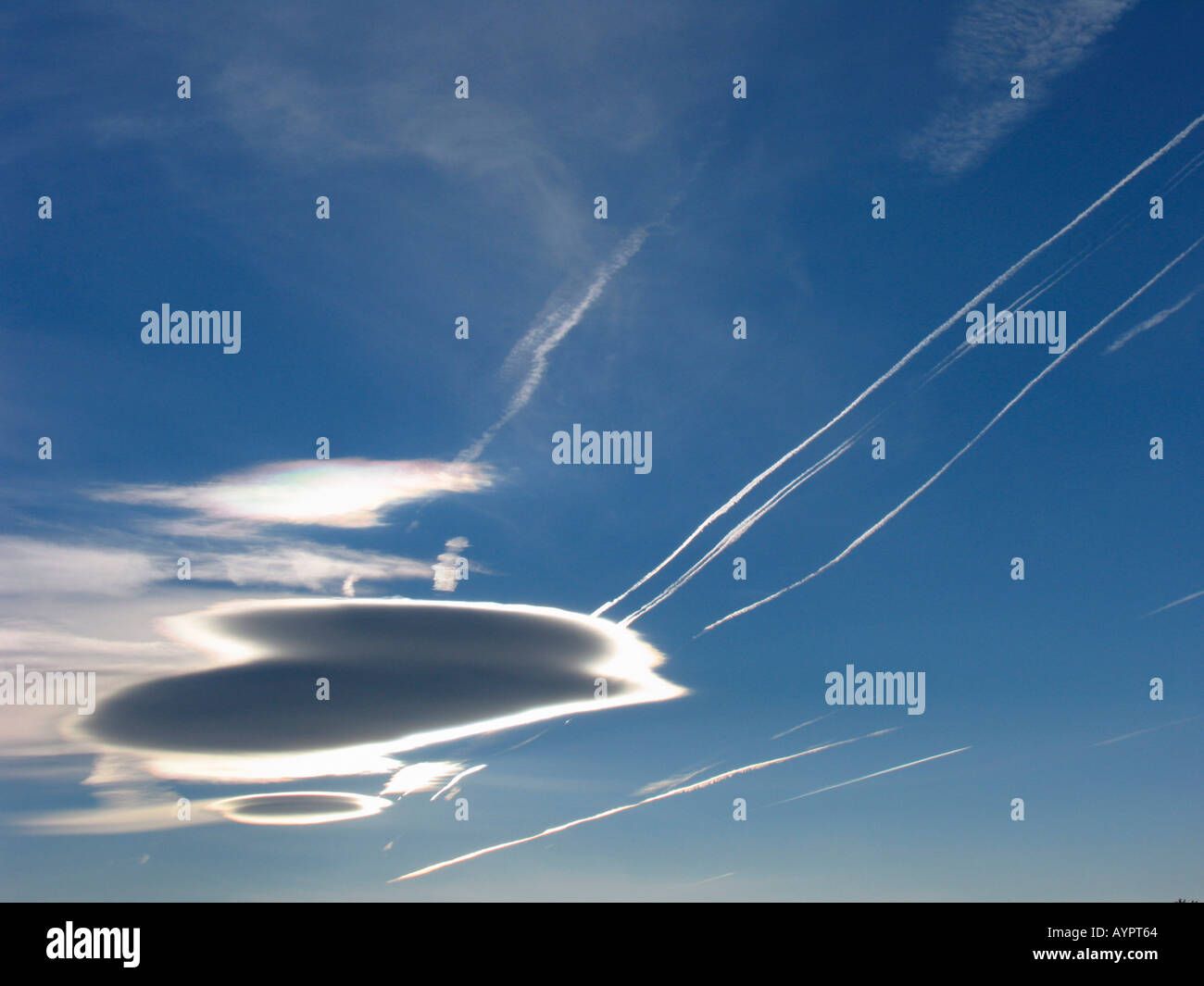 Jet trails through lenticular cloud formations. Spain Stock Photo - Alamy