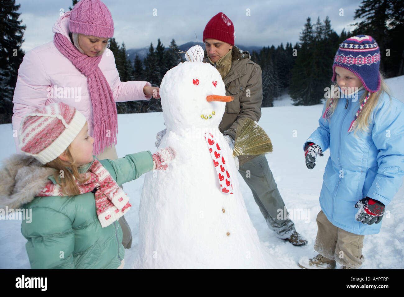 Family making a snowman Stock Photo - Alamy