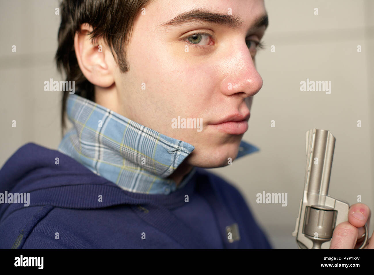 Young man with a gun looking at camera Stock Photo - Alamy