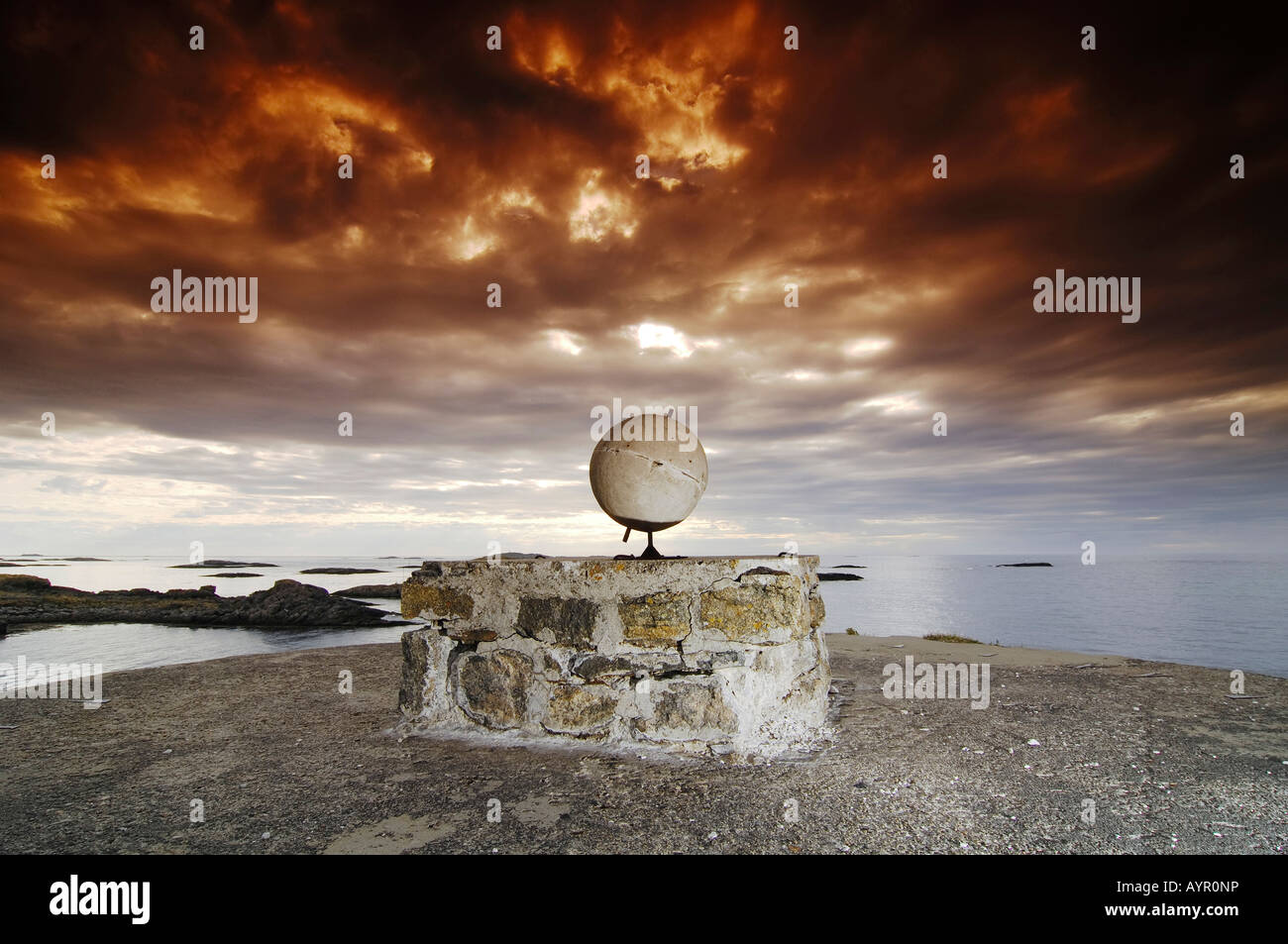 Unknown sculpture, dramatic red cloudy sky, concrete globe on a stone ...